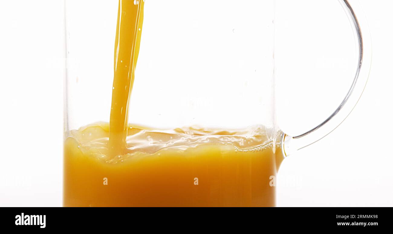 Orange Juice being poured into Glass against White Background Stock ...