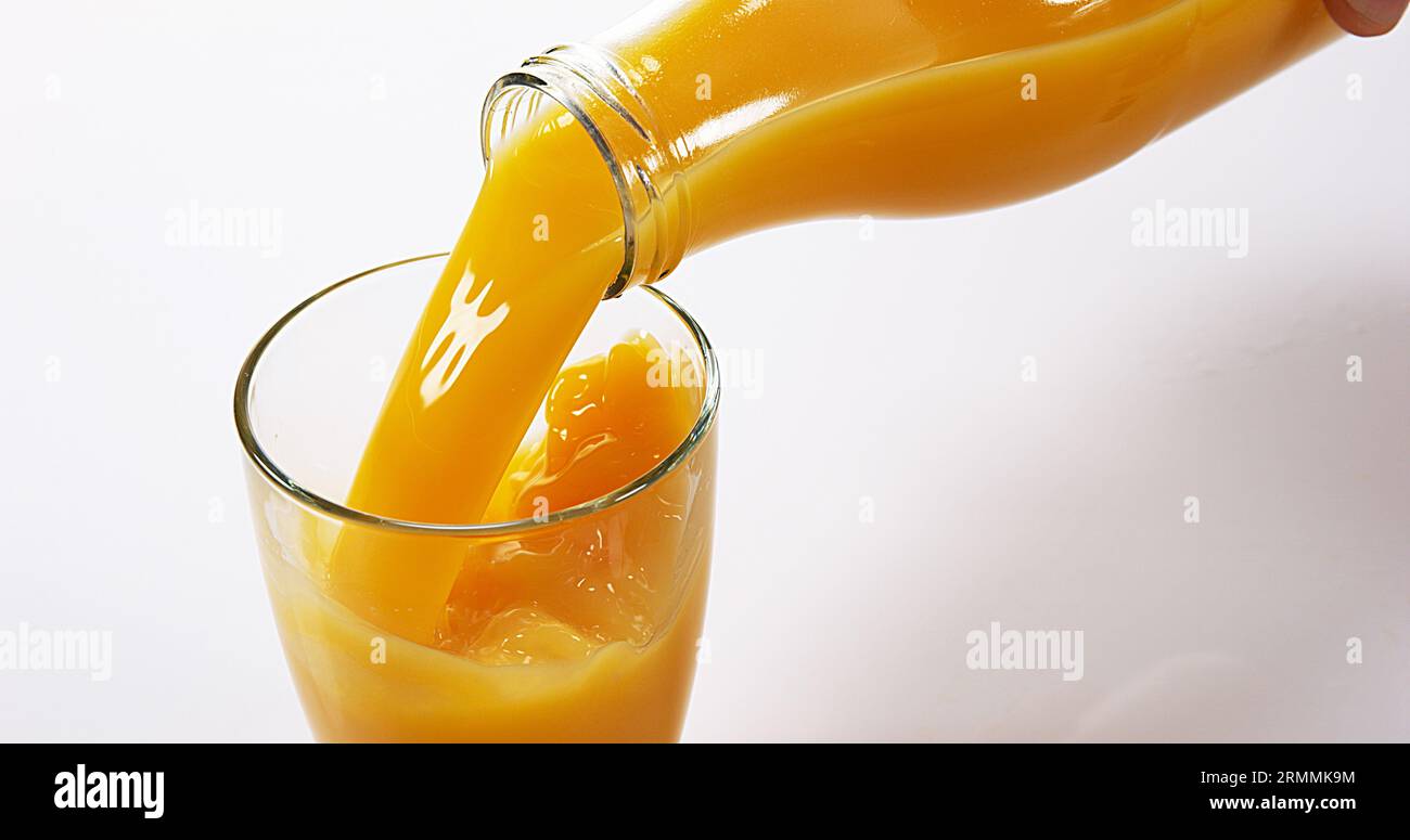 Orange Juice being poured into Glass against White Background Stock ...