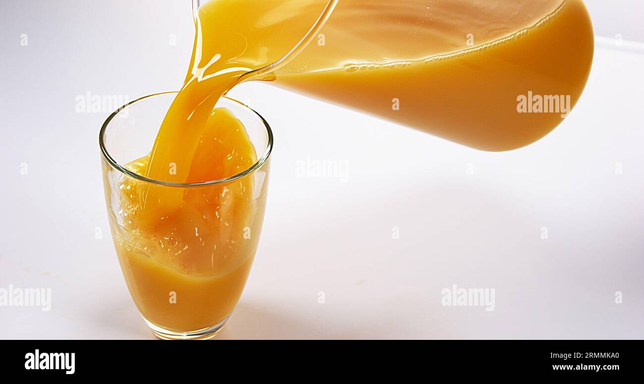 Orange Juice being poured into Glass against White Background Stock ...