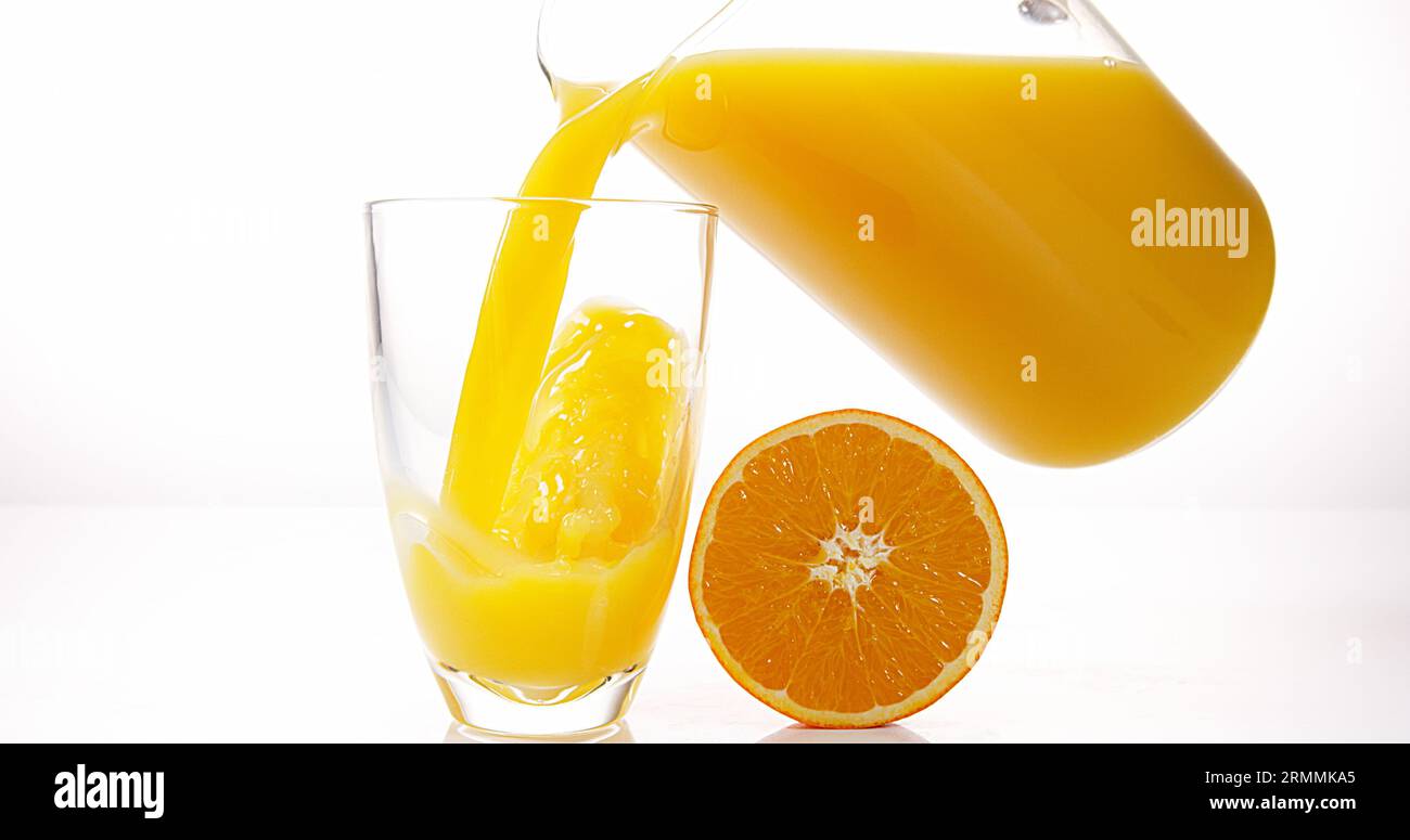 Orange Juice being poured into Glass against White Background Stock ...