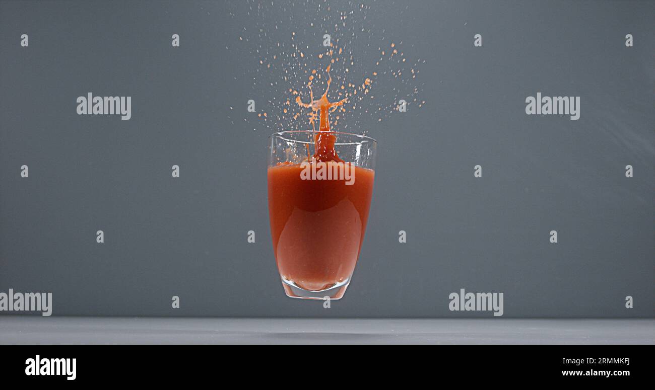 Glass of Tomatoe's Juice falling Stock Photo - Alamy