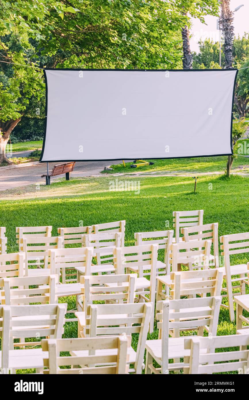 Open-Air Cinema: An empty white screen awaits projection in a park ...