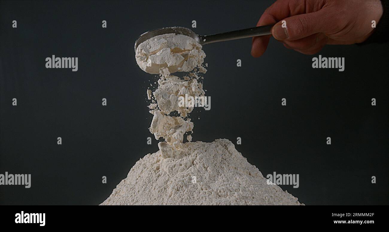 Flour falling against Black Background Stock Photo - Alamy