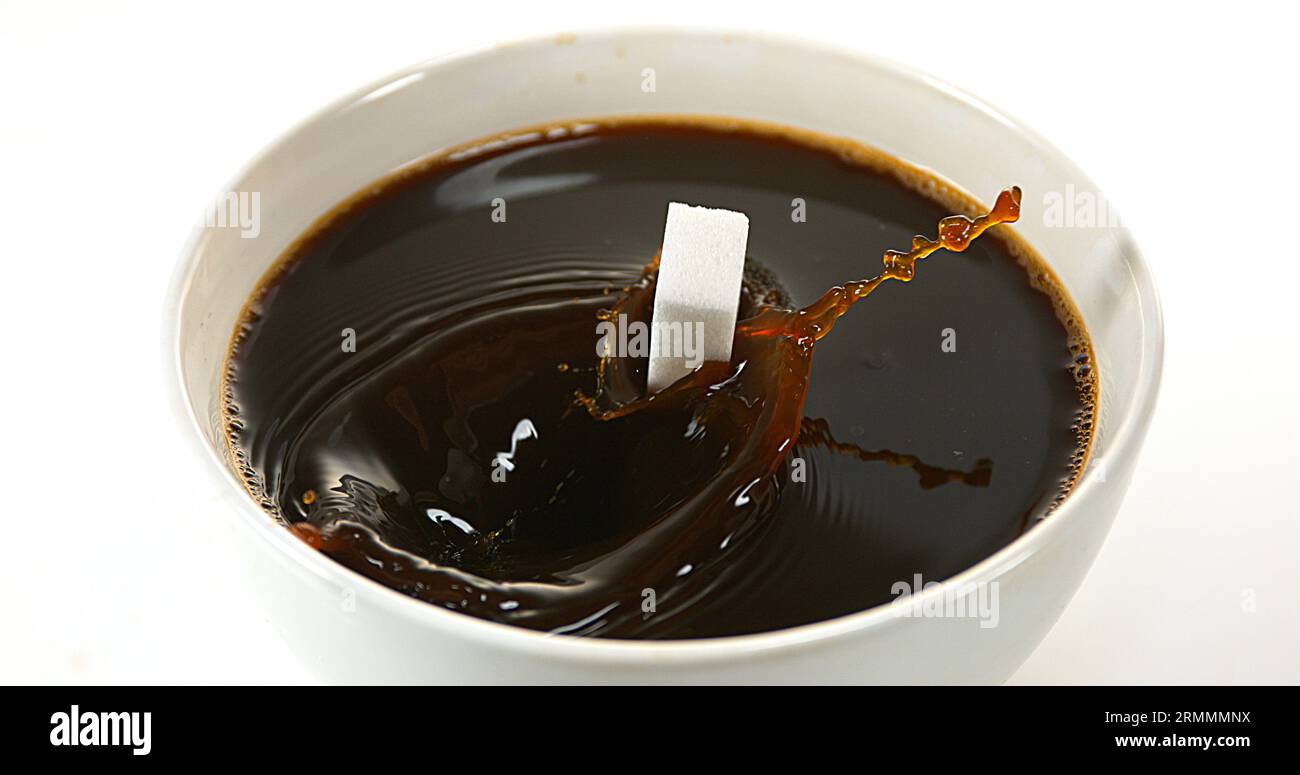 Sugar Falling into Bowl of Coffee against White Background Stock Photo ...