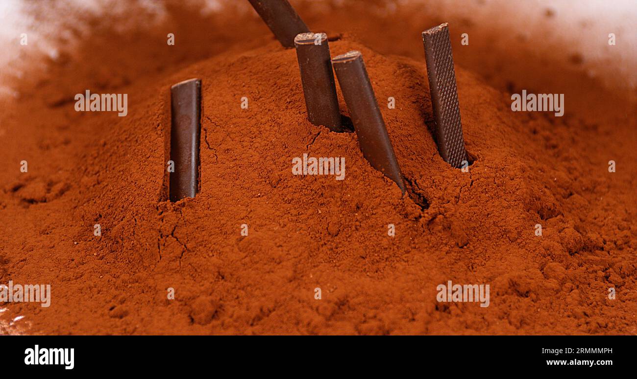 Chocolate Bars falling on Black Chocolate Powder Stock Photo - Alamy