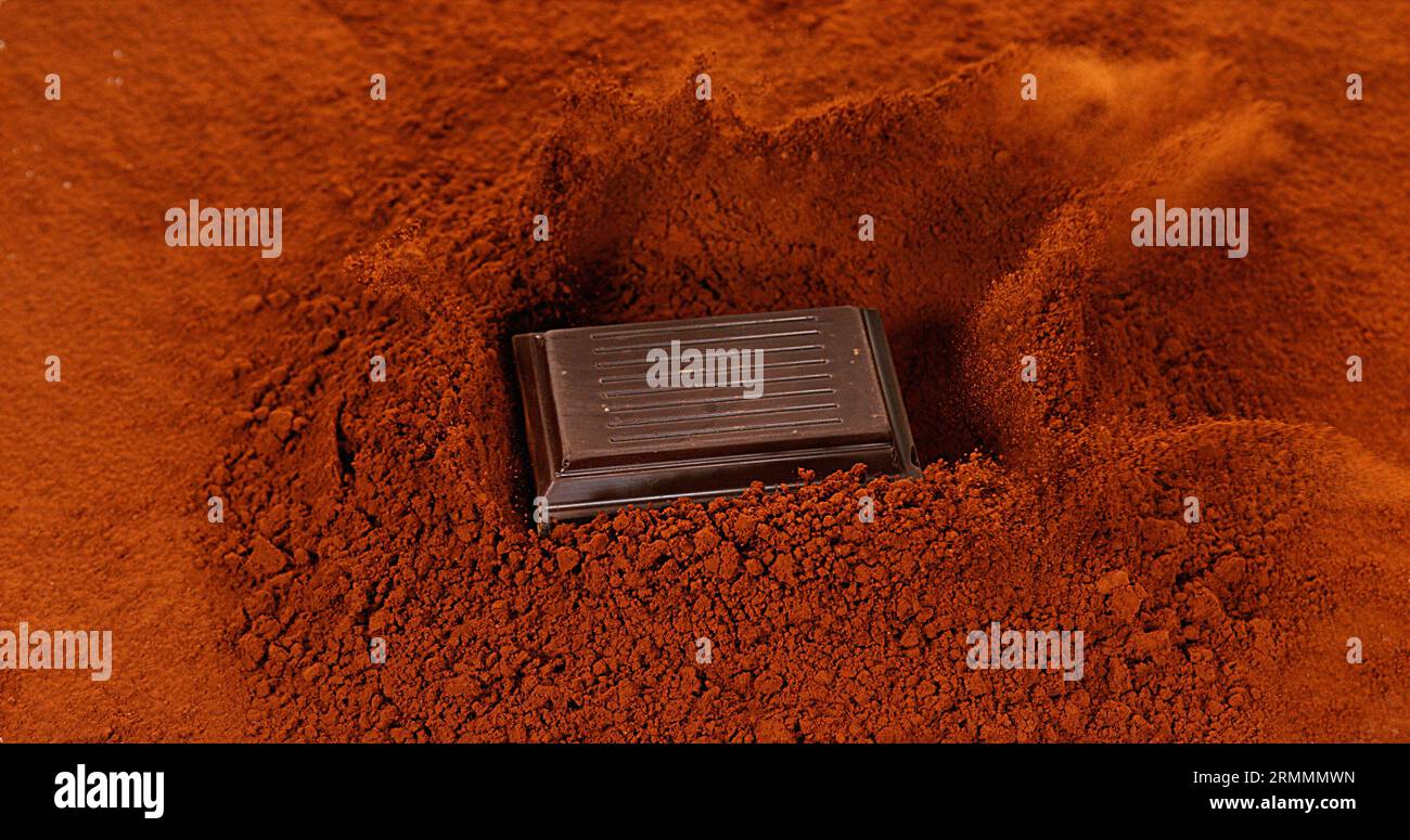 Black Chocolate Tablet falling on Black Chocolate Powder Stock Photo ...
