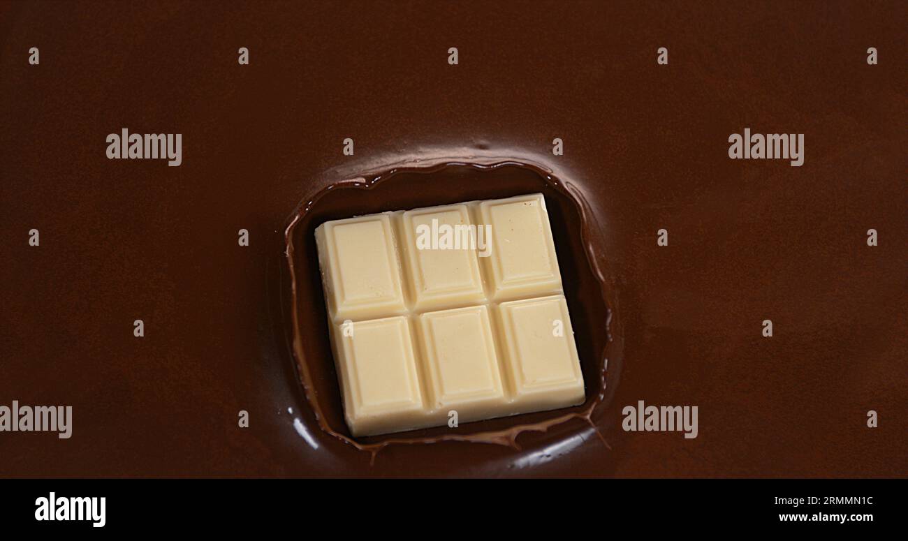 White Chocolate Tablet falling into Milk Chocolate Stock Photo - Alamy