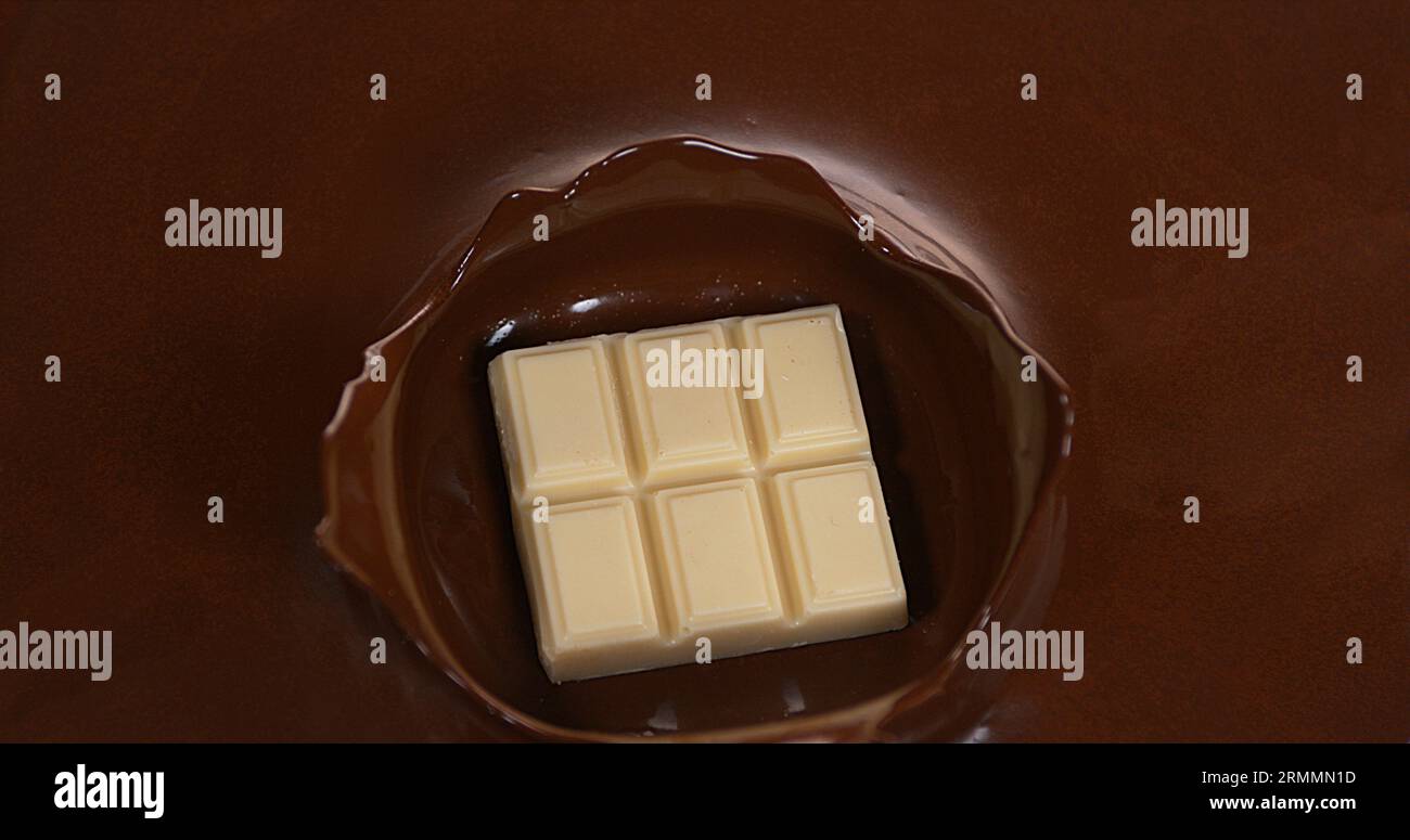 White Chocolate Tablet falling into Milk Chocolate Stock Photo - Alamy
