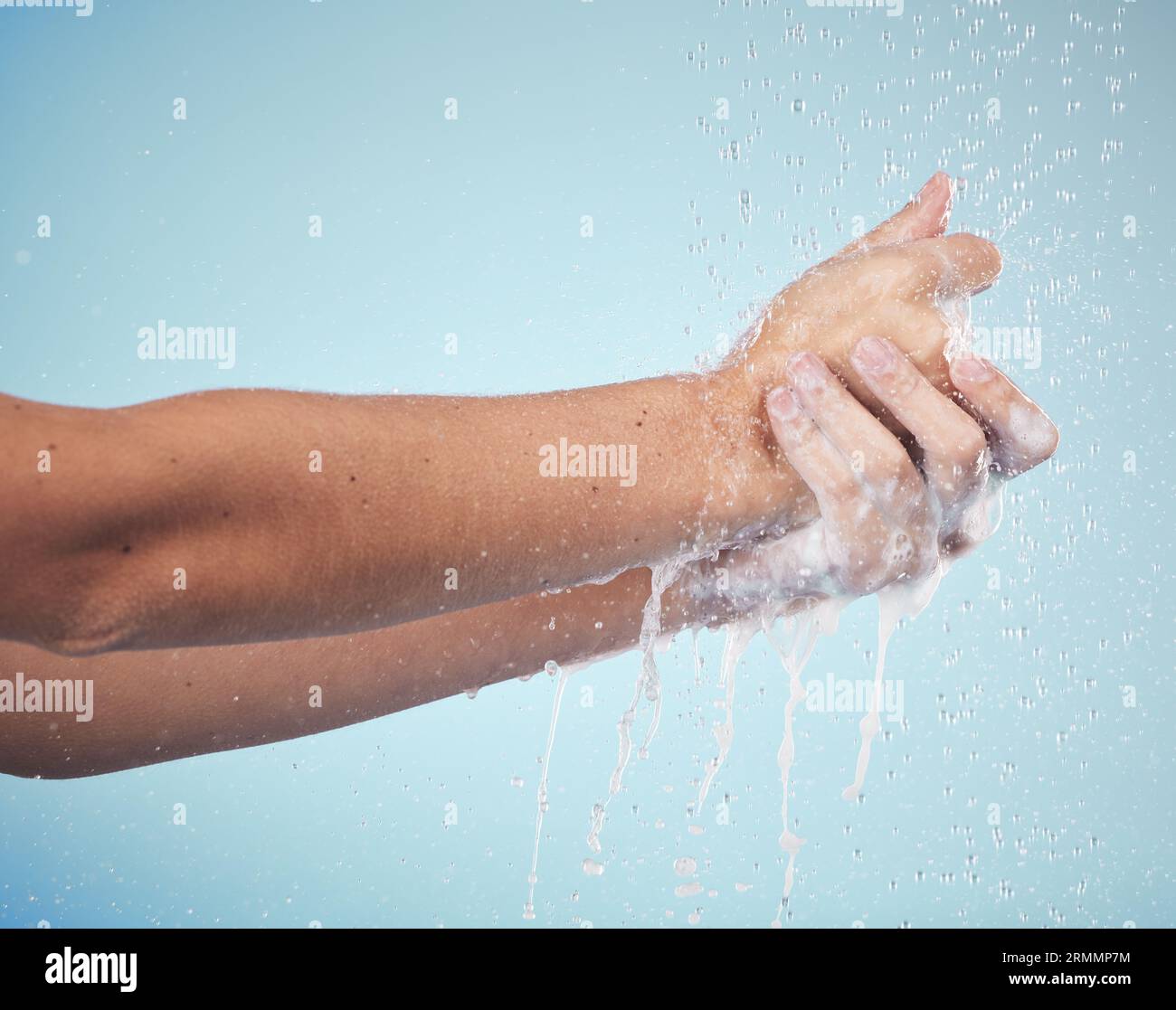 Hands, cleaning and woman with soap and water in studio, blue ...