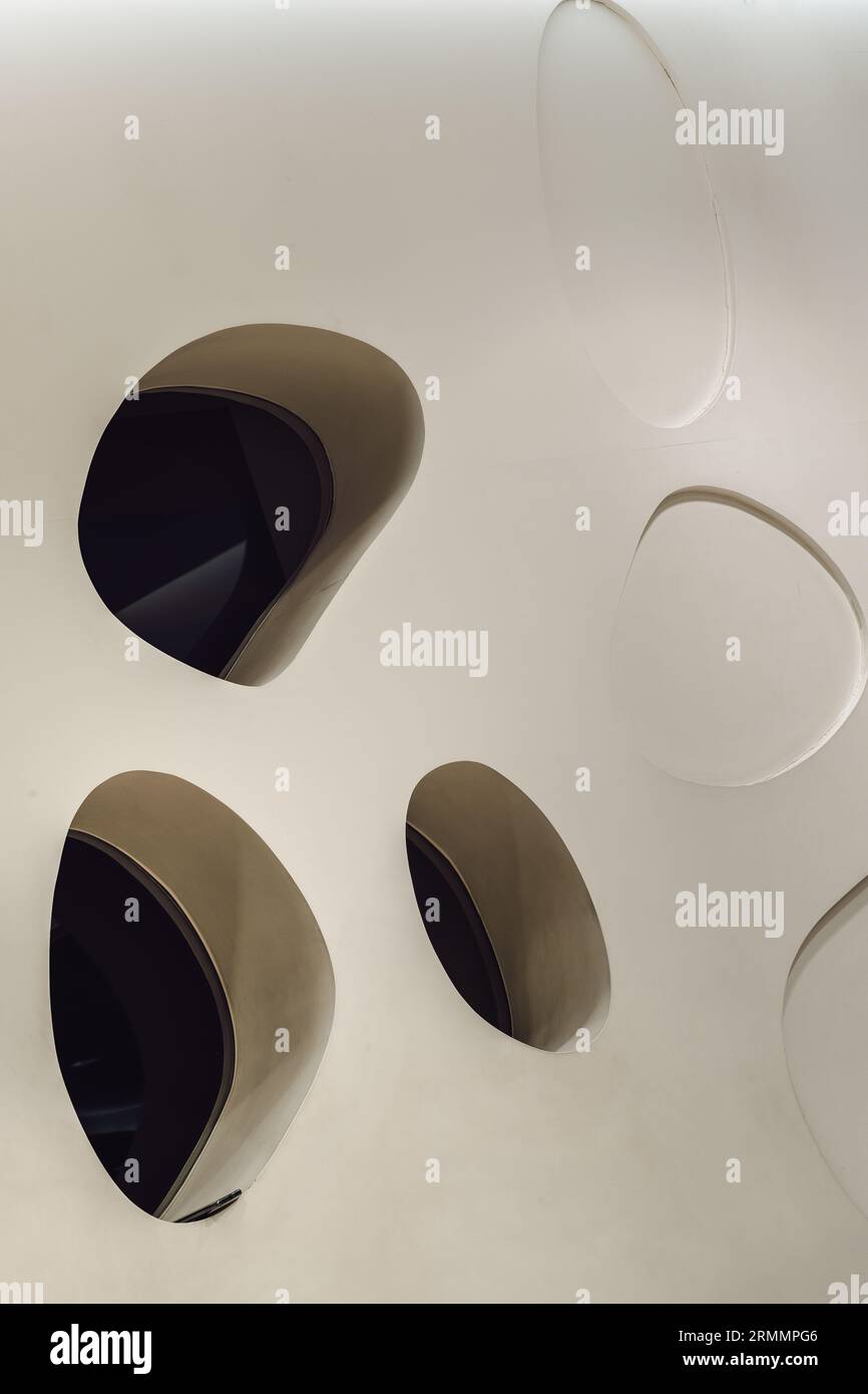 Glass mirrored panels are embedded in the white wall and are decorated ...