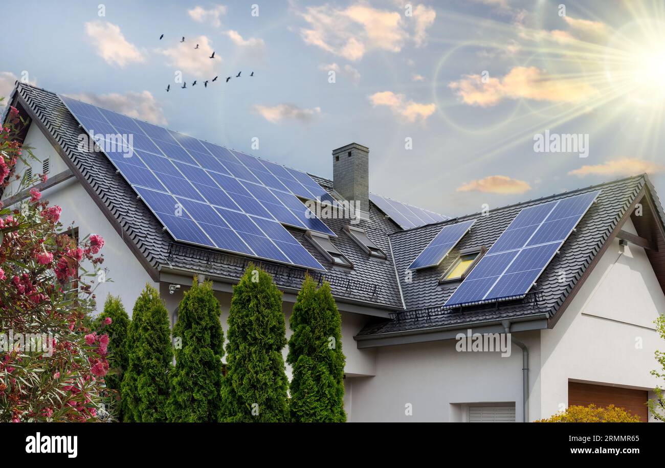 Beautiful modern house with solar panels surrounded by greenery. Clear ...