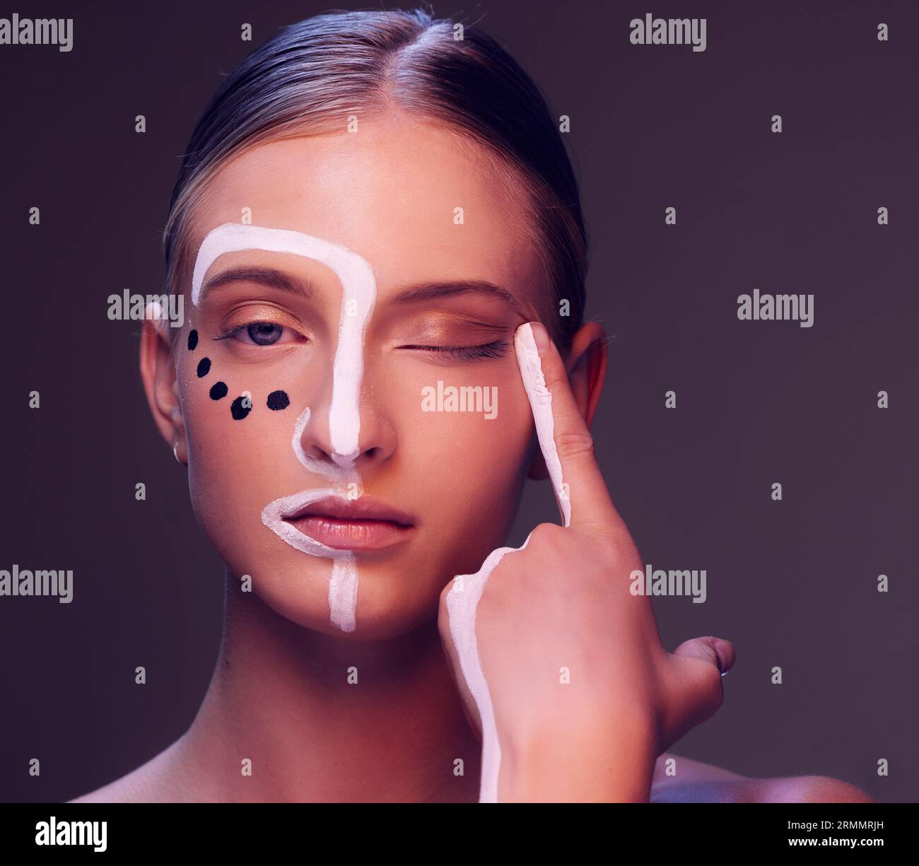 Woman, skin and paint in studio, wink and closeup for art, wellness or ...