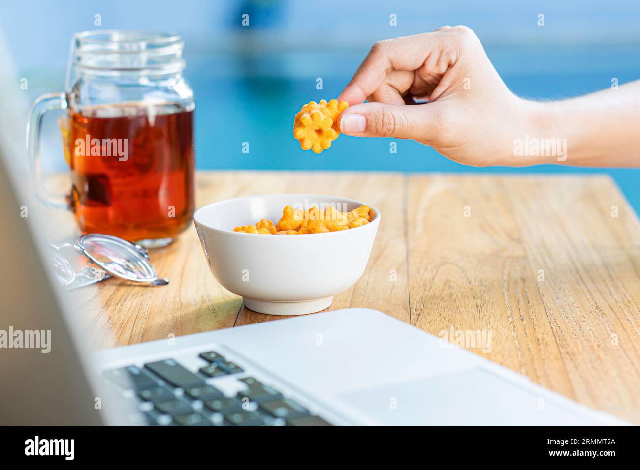 Entrepreneur hands holding snack bar working on laptop Stock Photo - Alamy