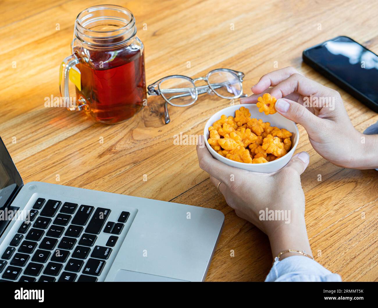 Entrepreneur hands holding snack bar working on laptop Stock Photo - Alamy