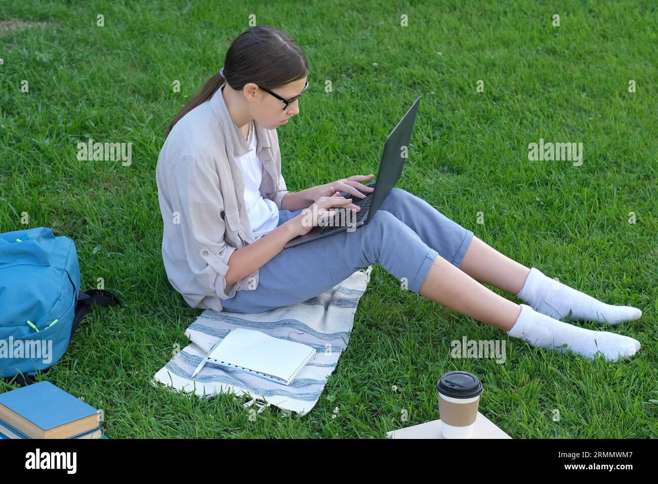 Teenage schoolgirl studying reading her books, tablet and notebook ...