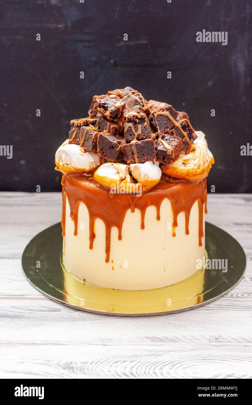 Delicious vanilla cake with chopped pieces of brownie, meringue clouds ...