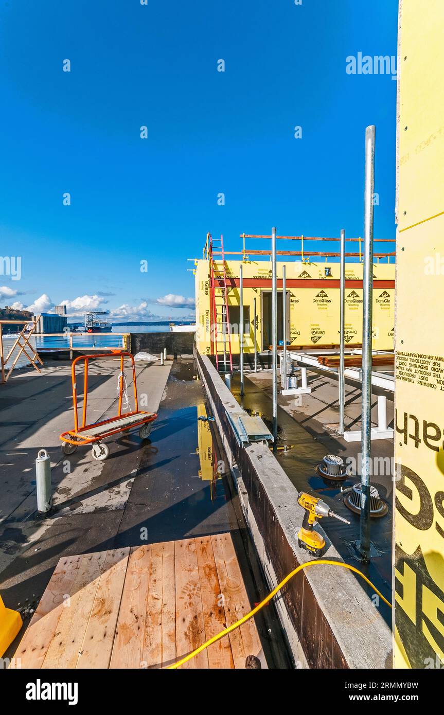 A cart and tools on the roof of a large commercial building under ...