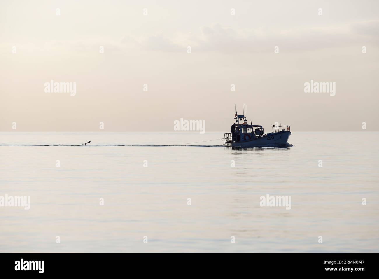 Small commercial fishing boat heading out to calm sea, Bright ...