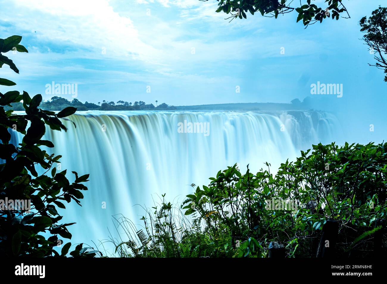 A scenic view of Victori Falls, Zimbabwe, featuring lush green foliage ...