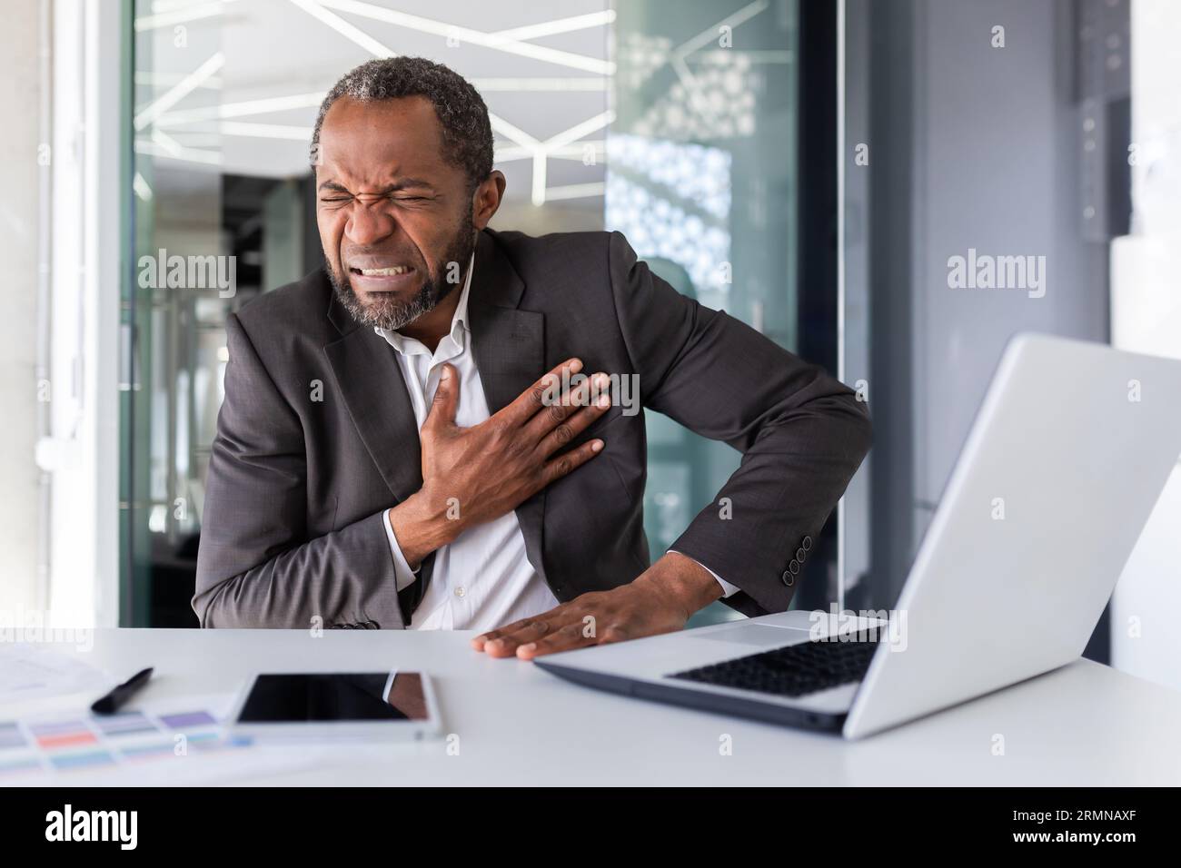 Heart attack in mature experienced man inside office at workplace ...