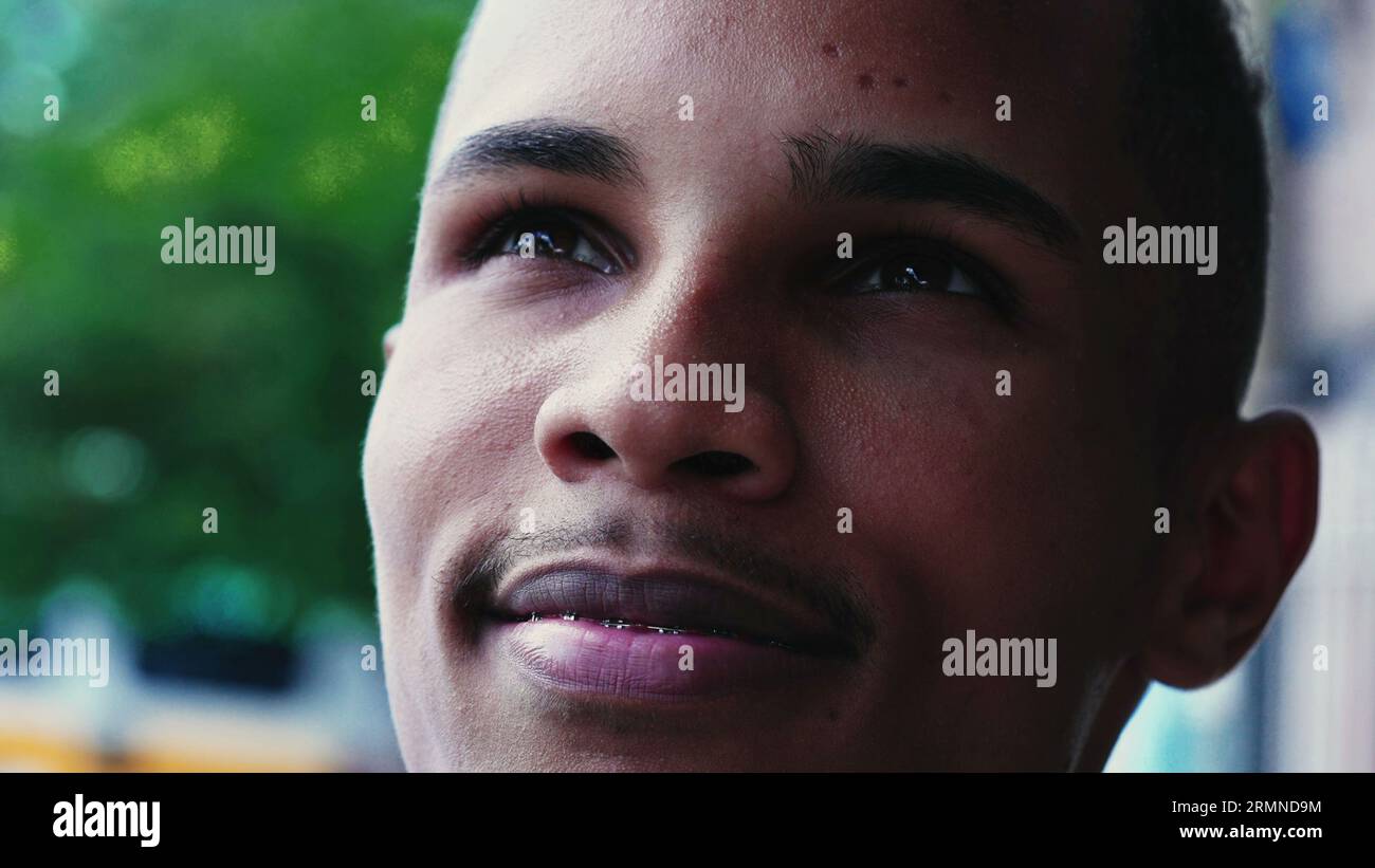 Religious Brazilian young man close-up face closing eyes and gazing upwards in Spiritual ...