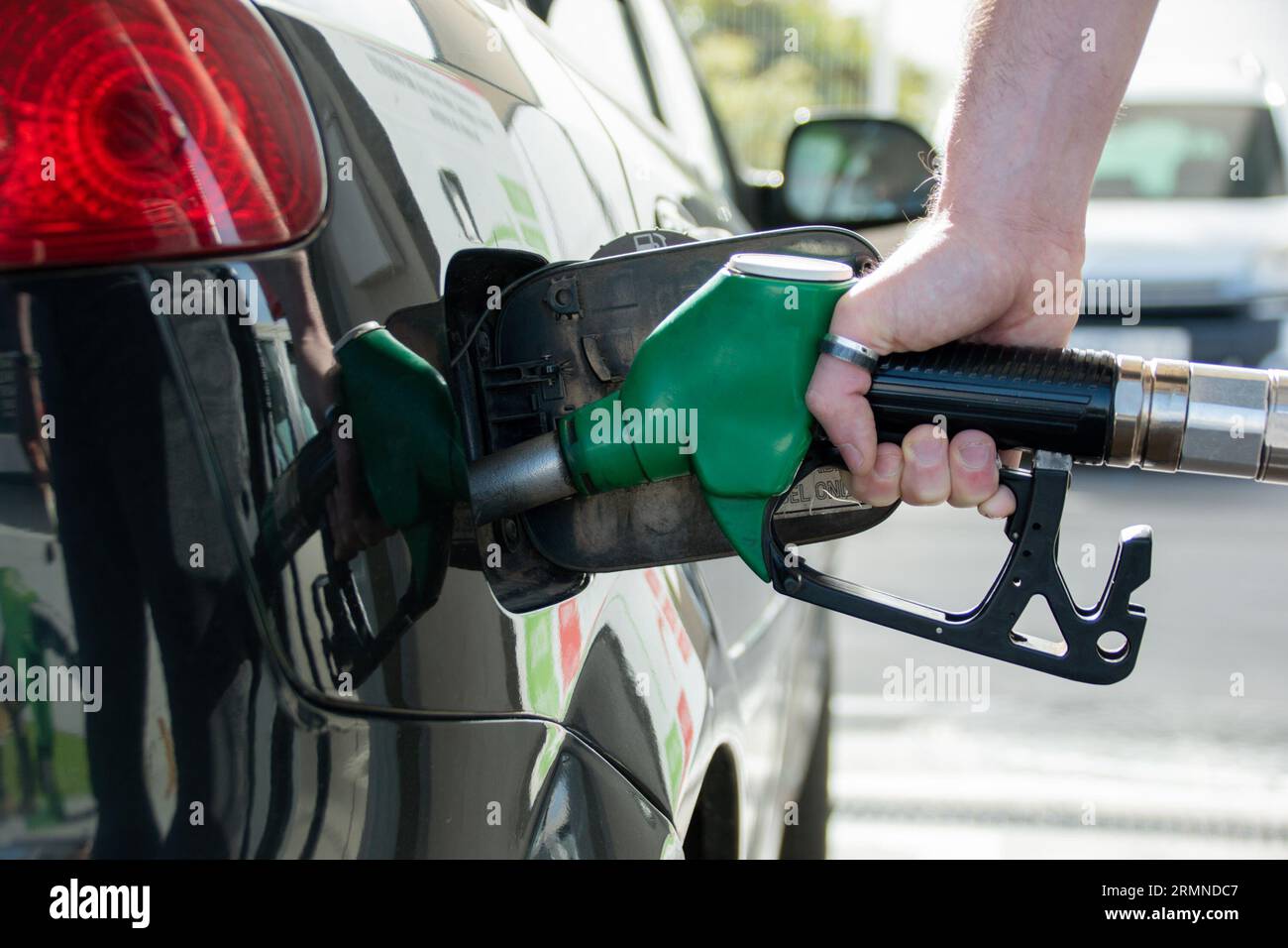 Close-up of the hand of a Caucasian man refueling his car with unleaded ...