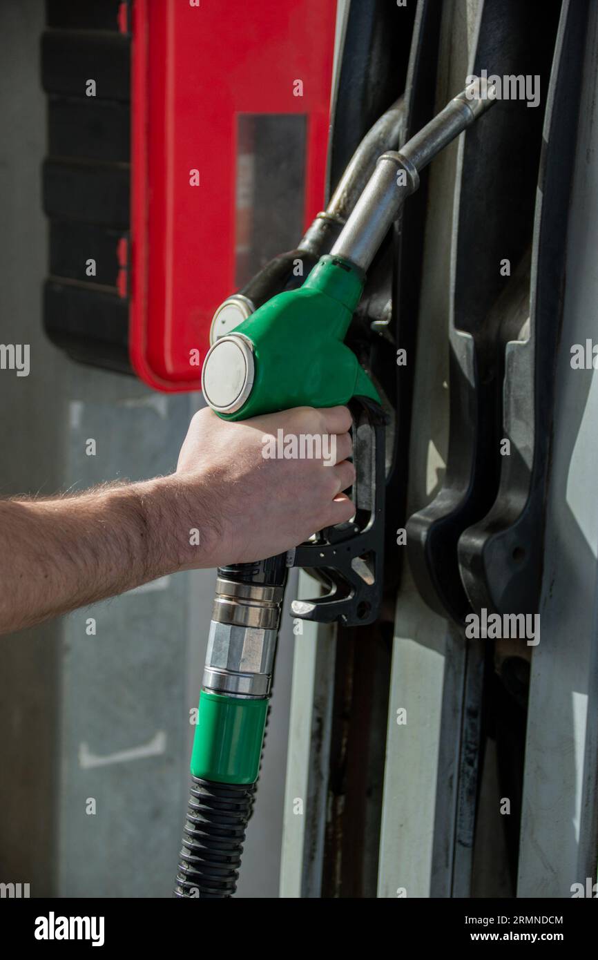 Close-up of a caucasian man's hand releasing the petrol pump after ...