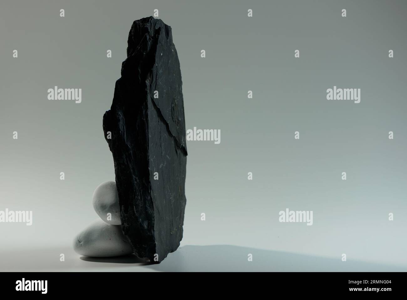 small white smooth stones behind one big black flat stone Stock Photo ...