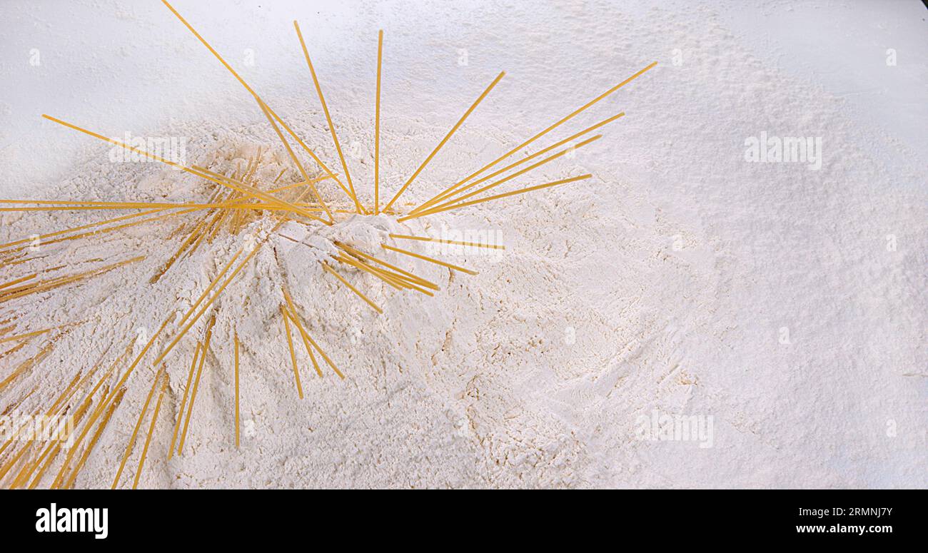 Pasta falling on flour against White Background Stock Photo - Alamy