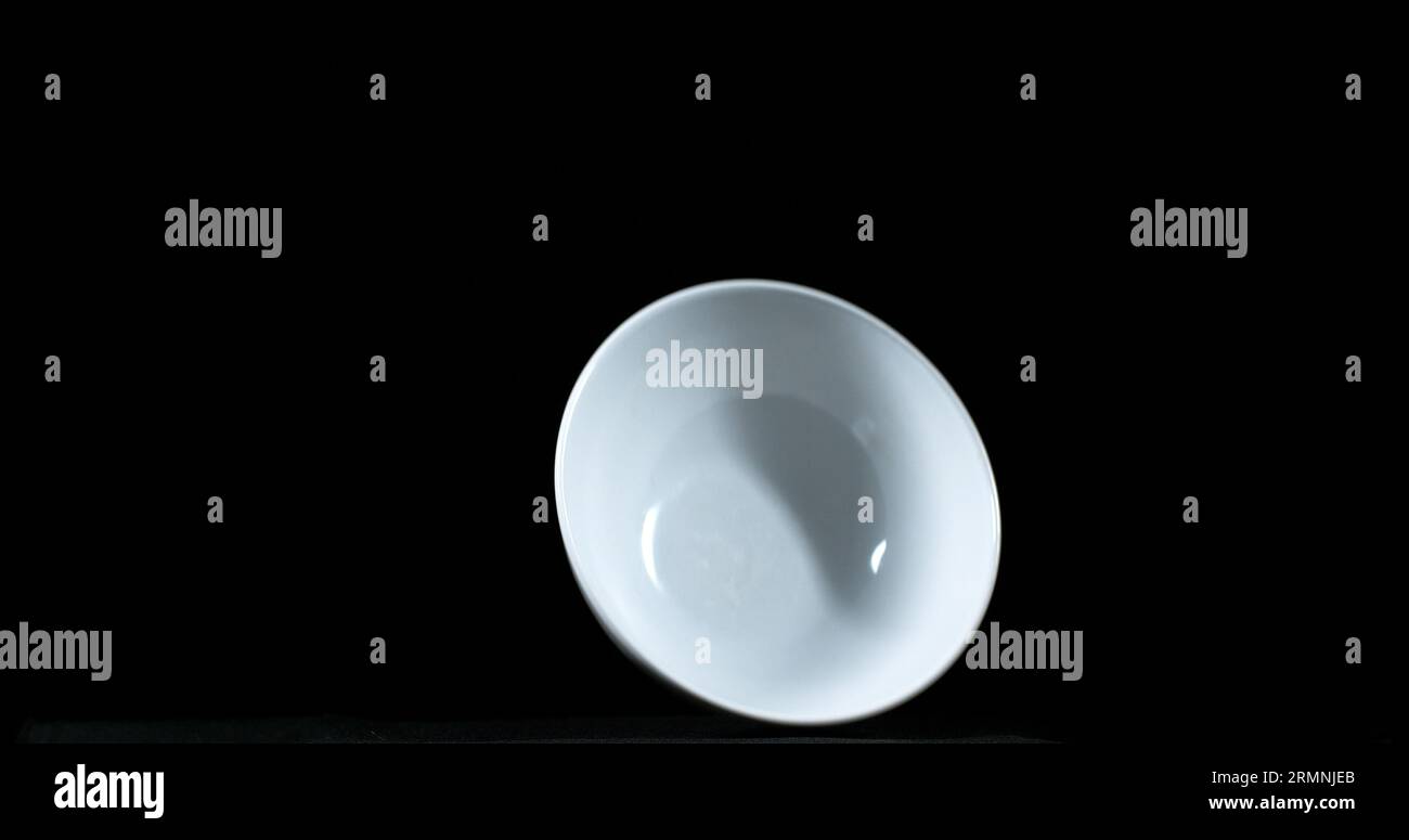 Bowl falling on Black Background Stock Photo - Alamy