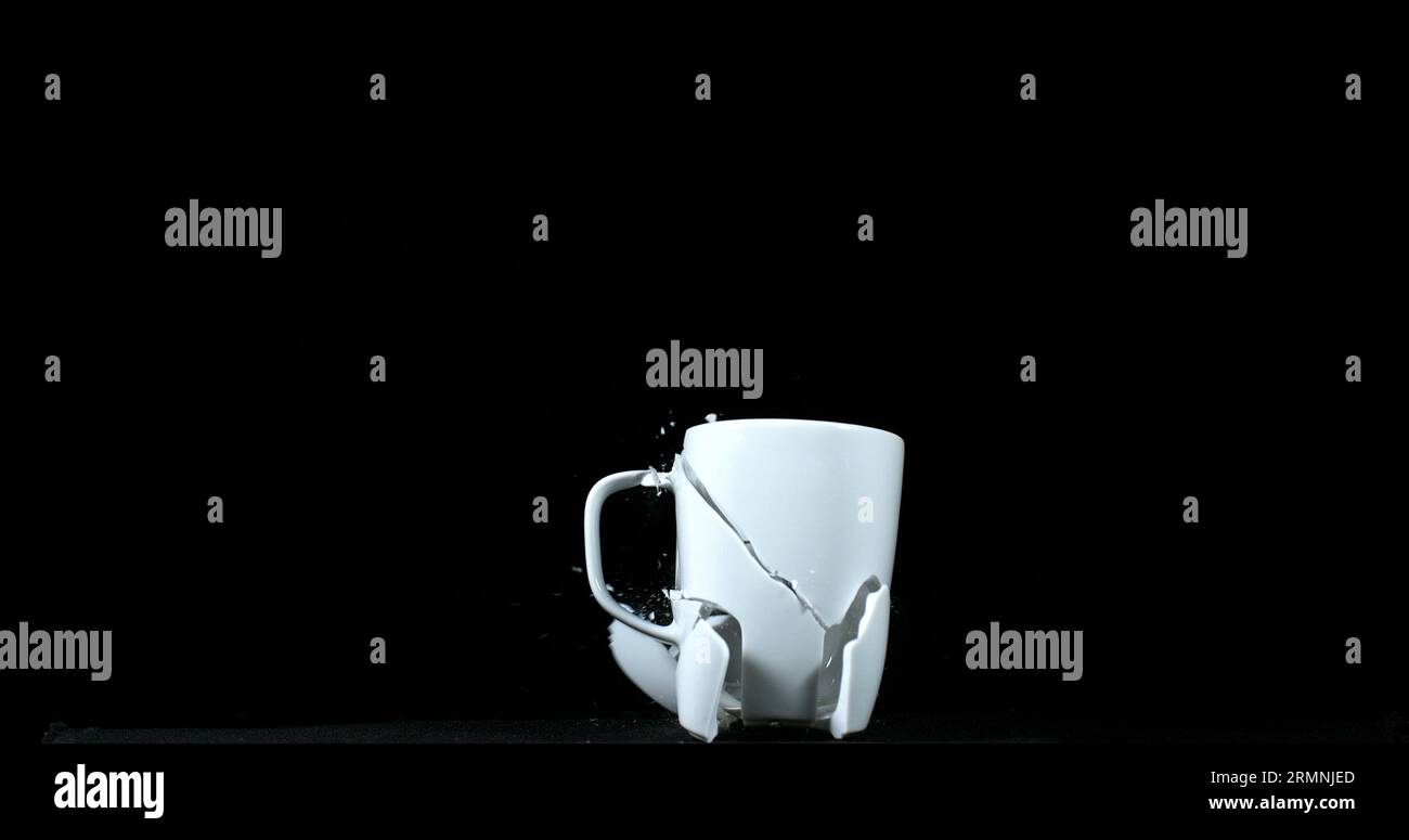 Cup falling and exploding on Black Background Stock Photo - Alamy