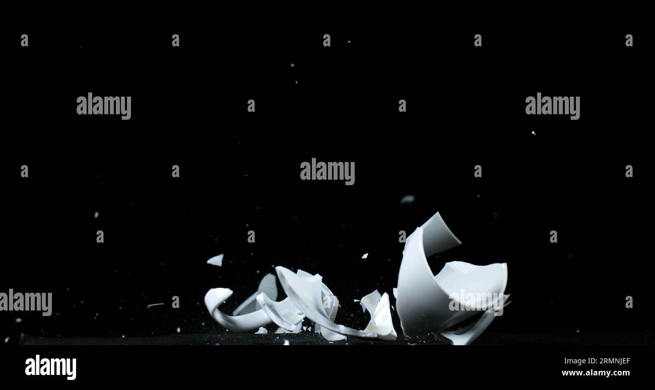 Cup falling and exploding on Black Background Stock Photo - Alamy