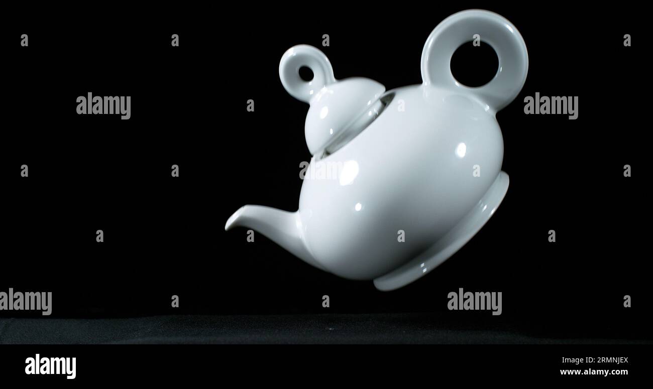 Tea-Pot falling on Black Background Stock Photo - Alamy