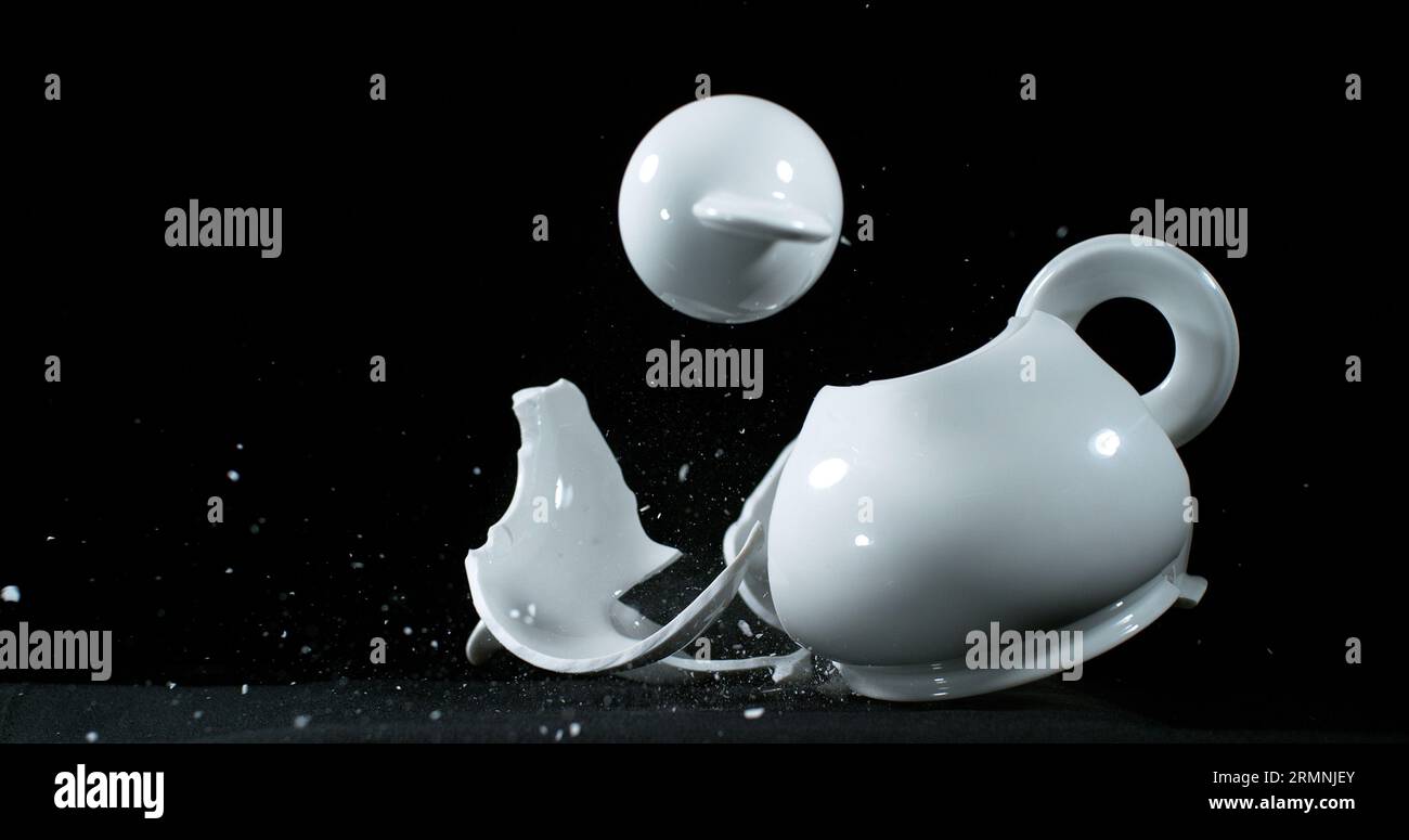 Tea-Pot falling and exploding on Black Background Stock Photo - Alamy
