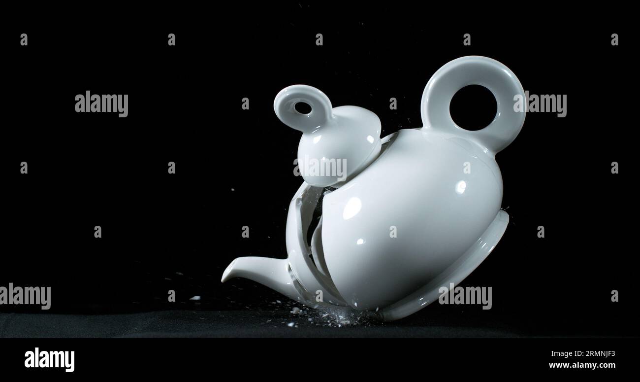 Tea-Pot falling and exploding on Black Background Stock Photo - Alamy