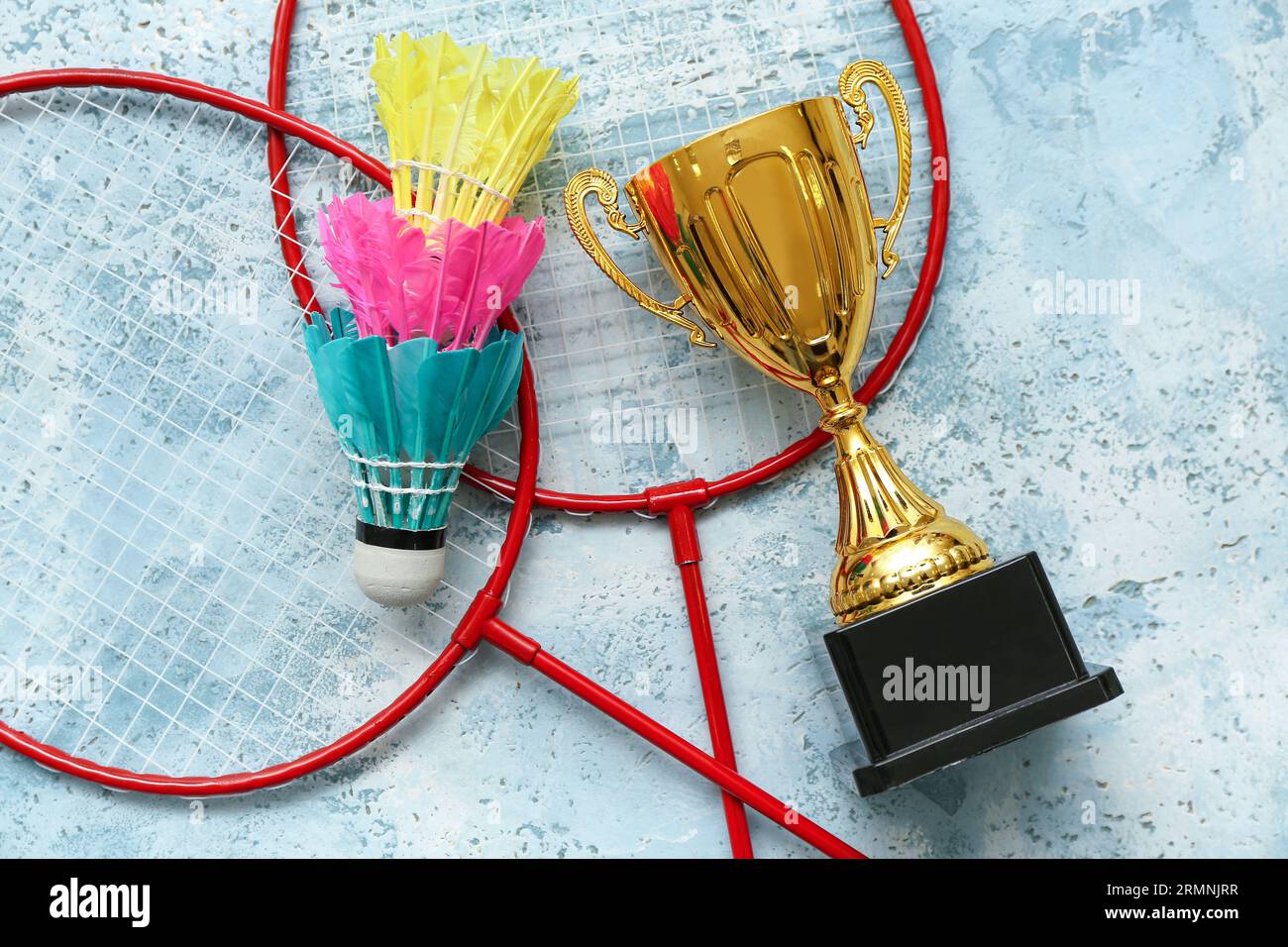 Gold cup with badminton rackets and shuttlecocks on grunge background ...
