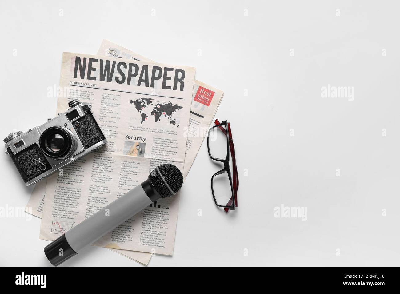 Newspaper with microphone, photo camera and eyeglasses on white ...