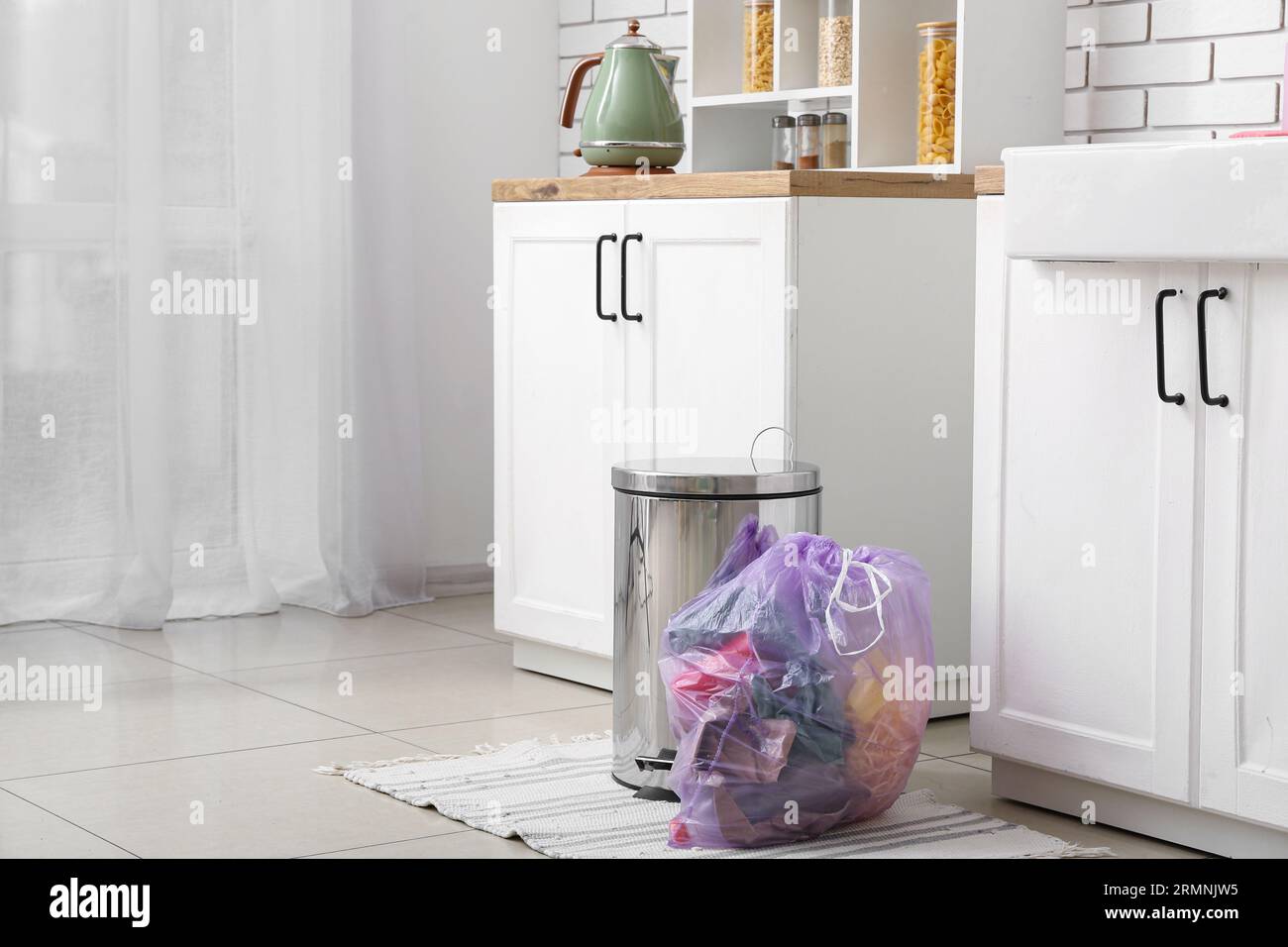 Trash bin and full garbage bag in interior of modern kitchen Stock ...