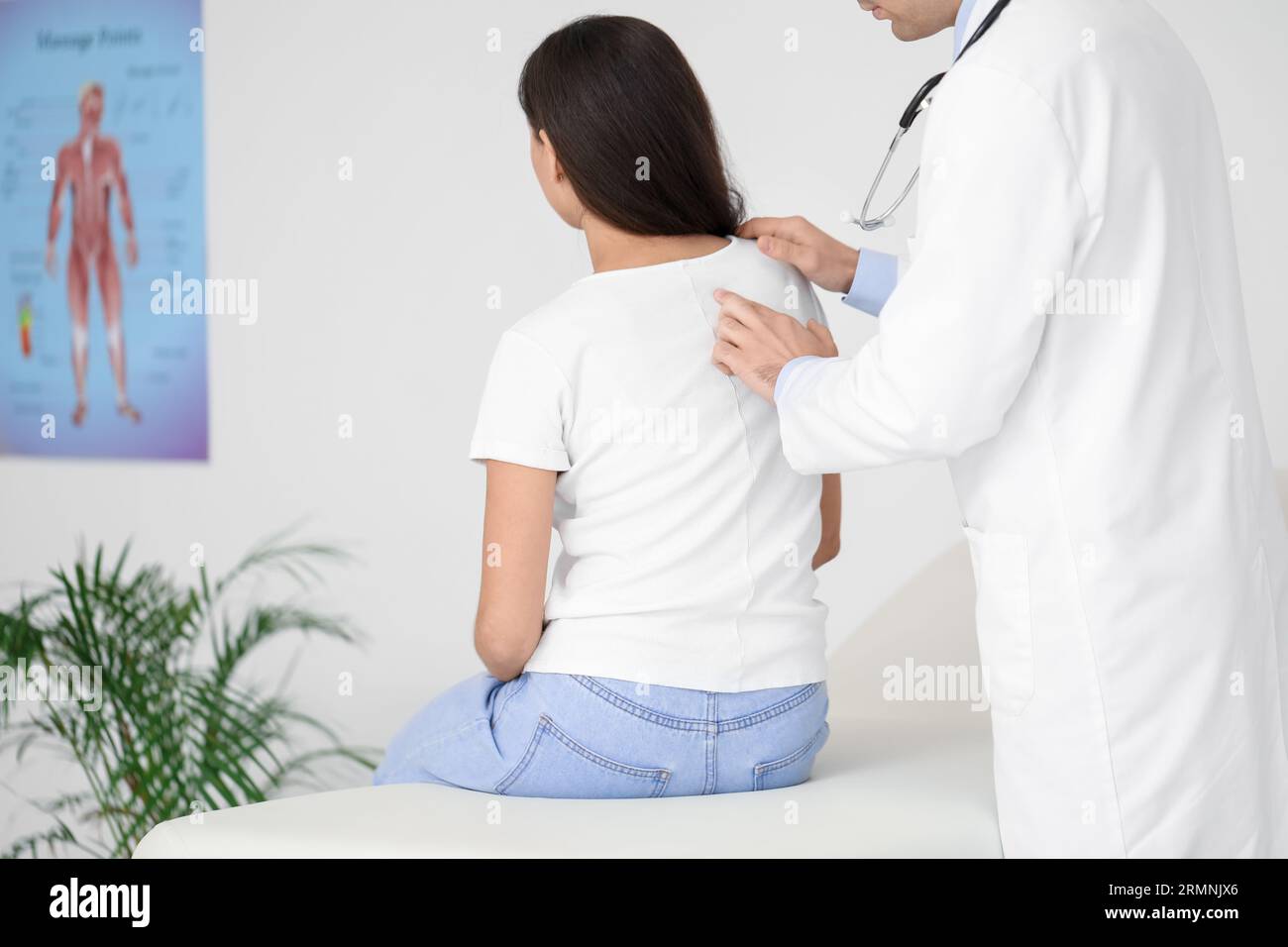 Male doctor checking posture of young woman in clinic Stock Photo - Alamy