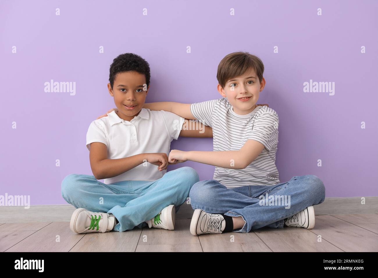 Cute little boys hugging near lilac wall Stock Photo - Alamy