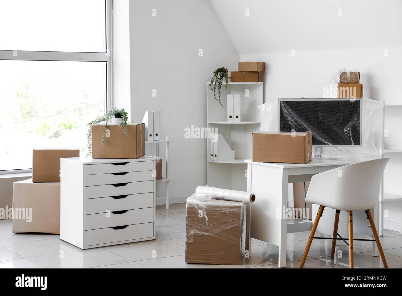 Interior of light office with cardboard boxes and stretch film on ...