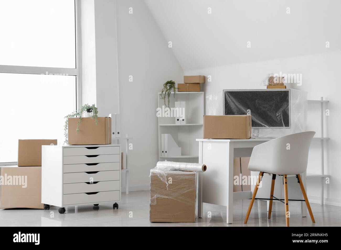 Interior of light office with cardboard boxes and stretch film on ...