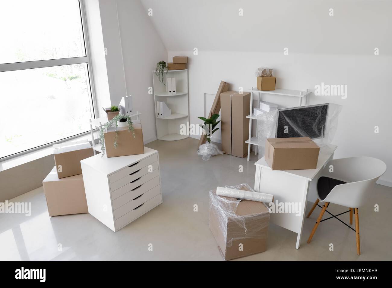 Interior of light office with cardboard boxes and stretch film on ...