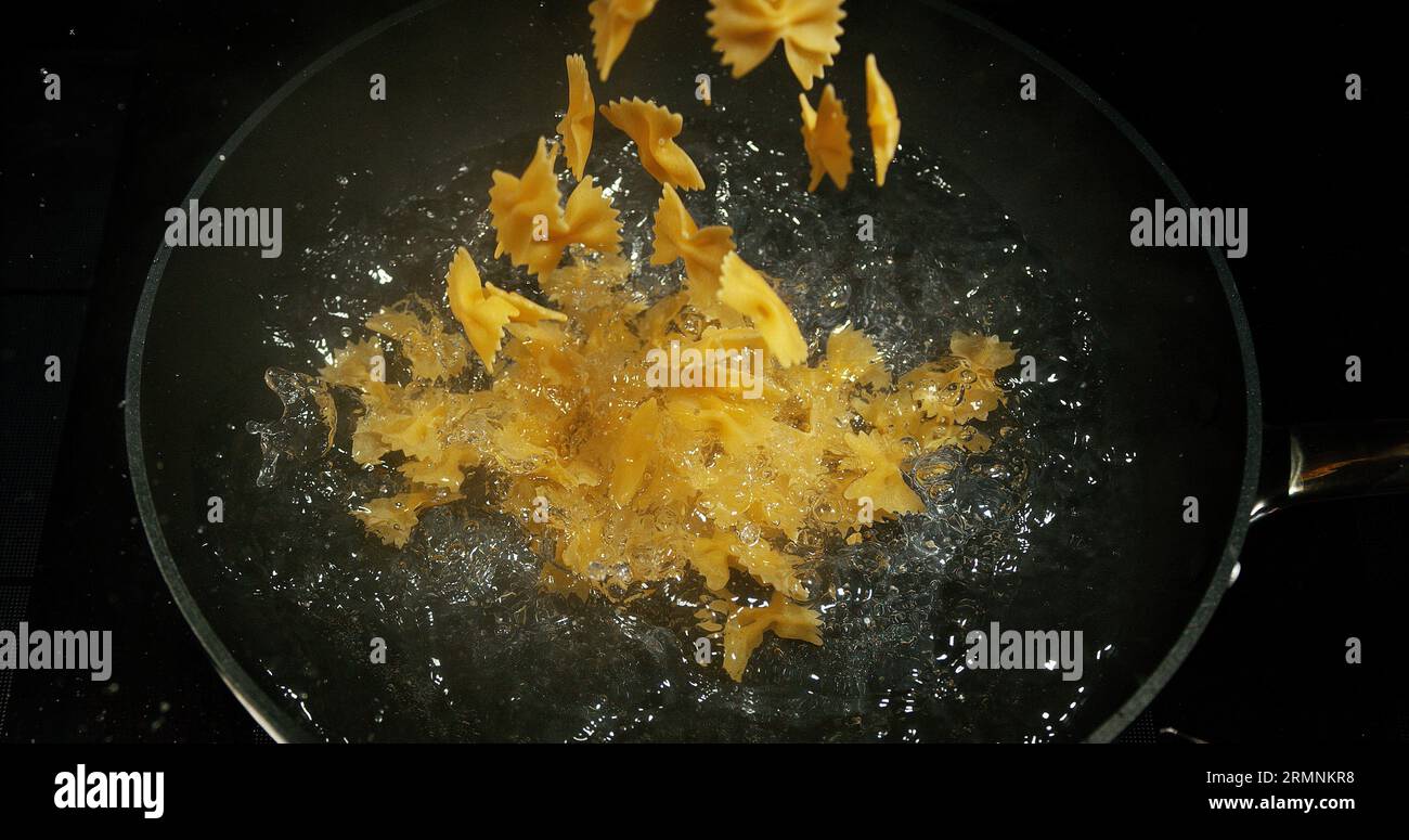 Pasta falling into boiling water Stock Photo - Alamy