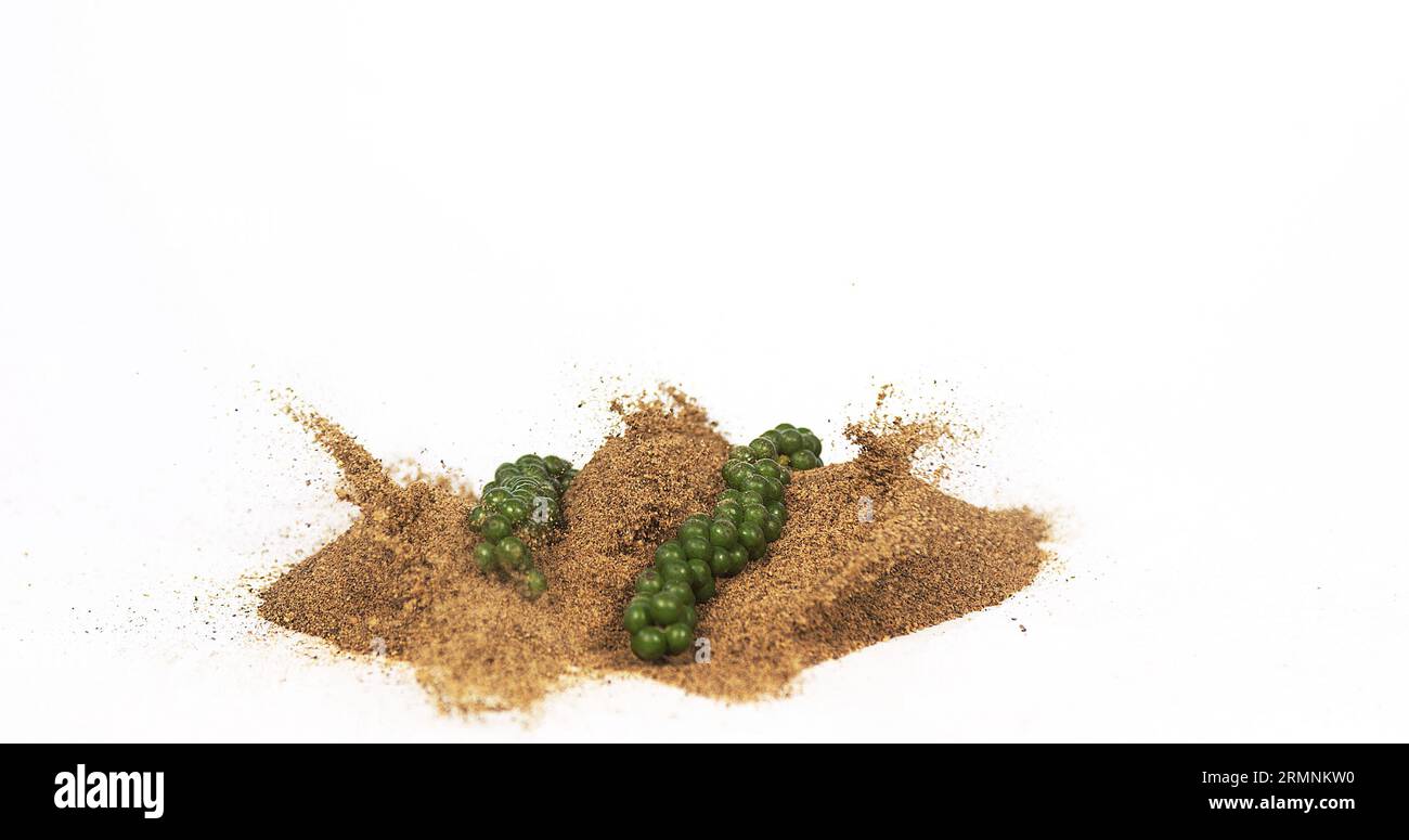 Fresh green pepper, piper nigrum, spice falling in pepper ground on ...