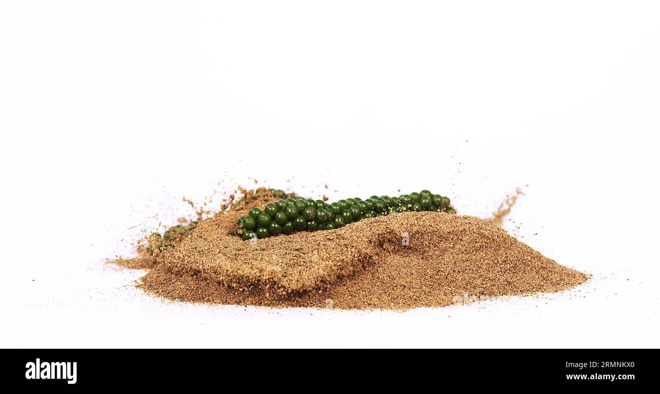 Fresh green pepper, piper nigrum, spice falling in pepper ground on ...