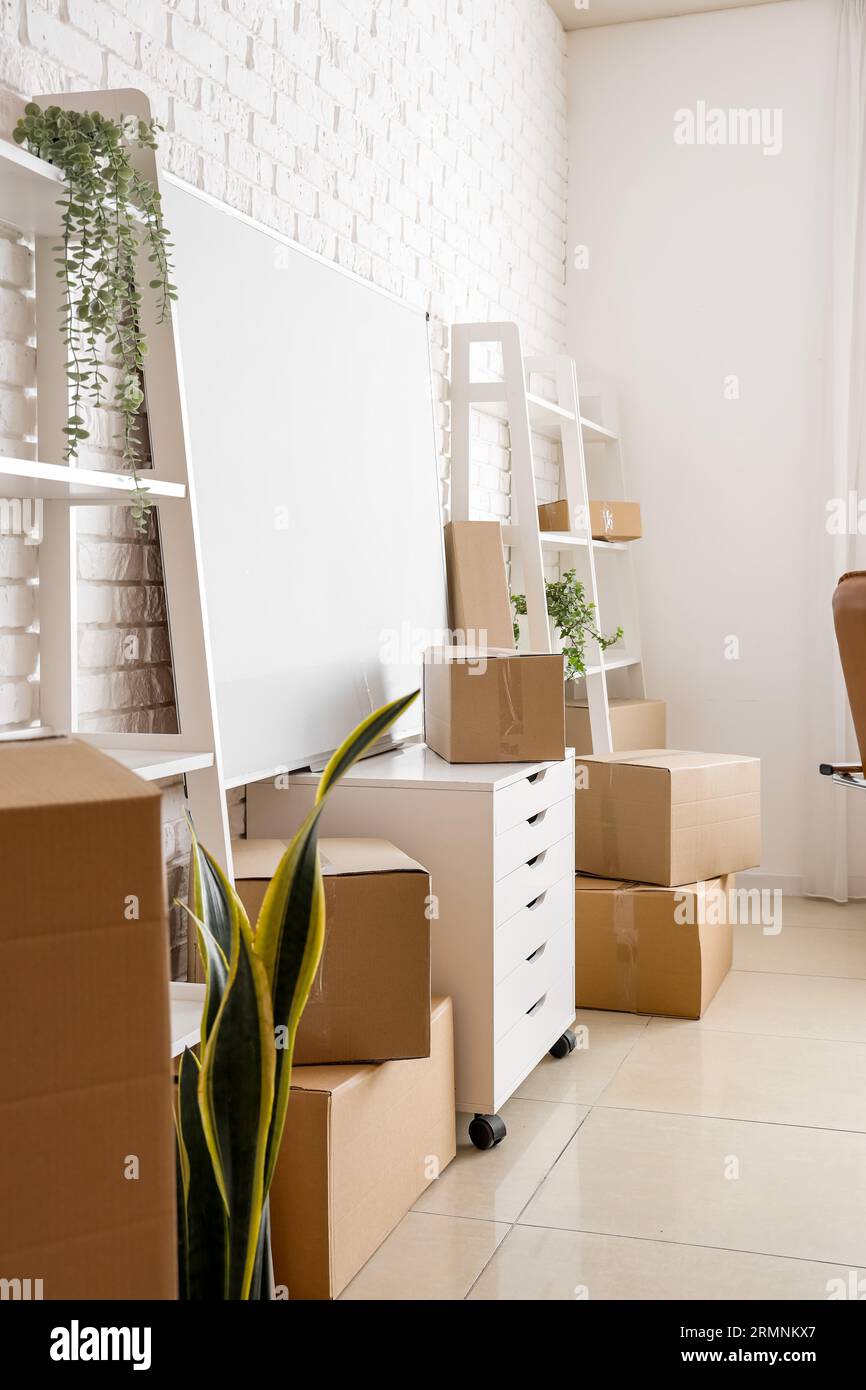 Chest of drawers with cardboard boxes in office on moving day Stock ...