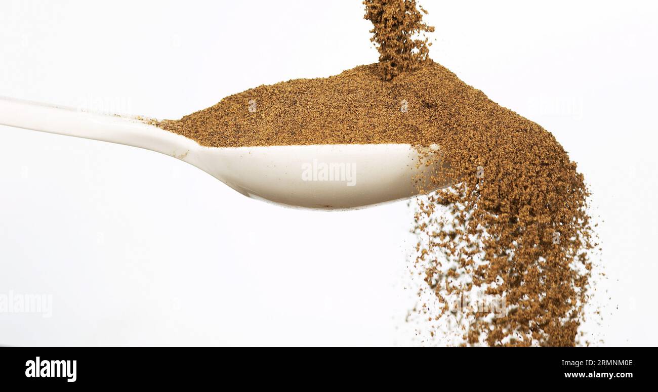 Green pepper, piper nigrum, spice falling on a Spoon against white ...