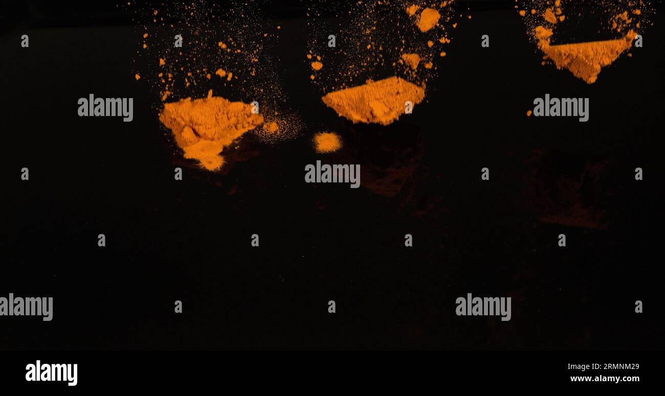 Turmeric, curcuma longa, Powder falling against Black Background ...