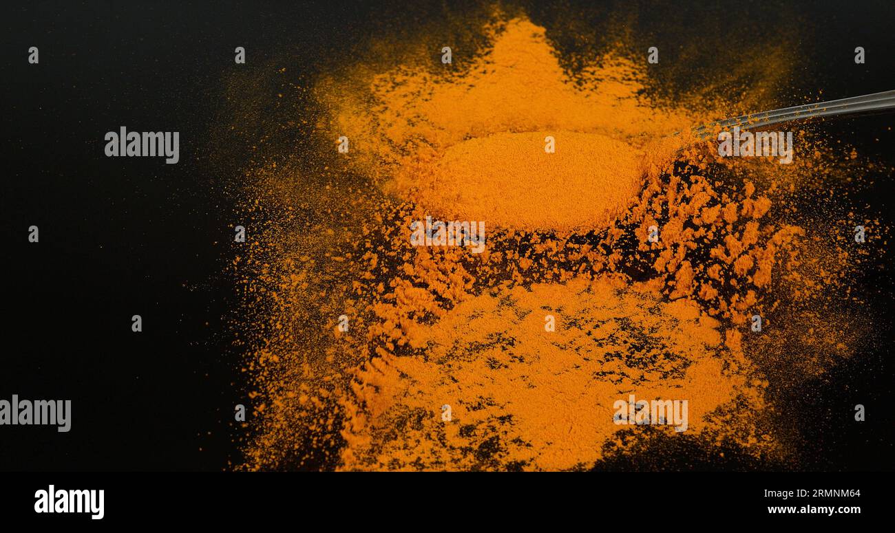 Turmeric, curcuma longa, Powder falling on Spoon against Black ...